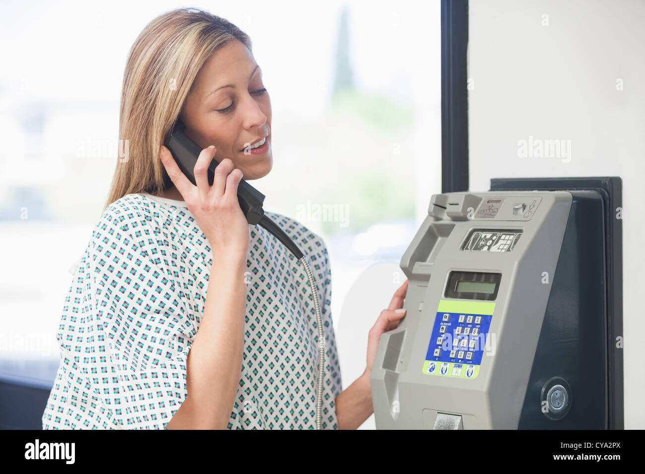 Female patient using payphone Stock Photo - Alamy