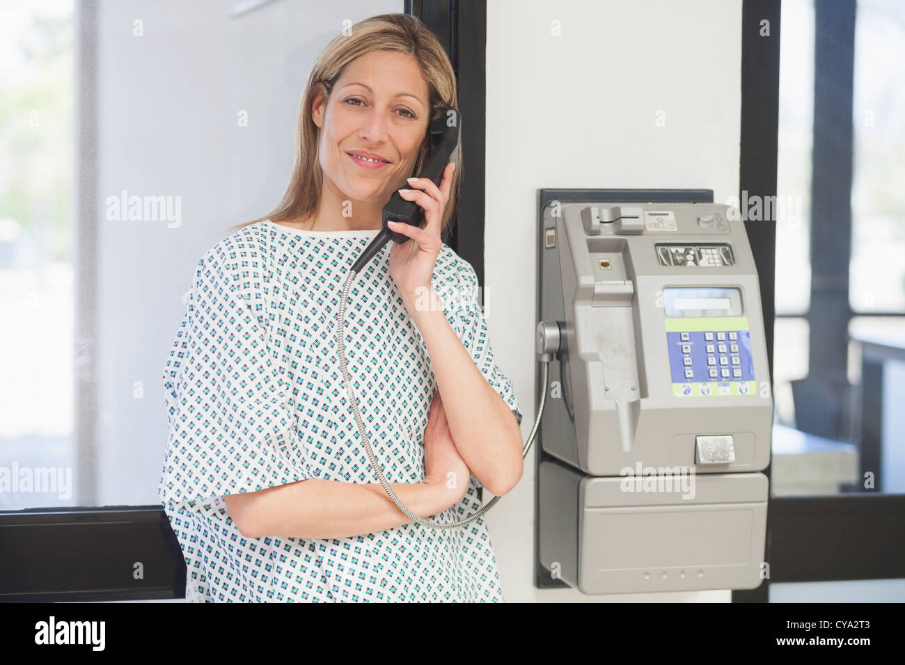 Smiling patient using payphone Stock Photo - Alamy