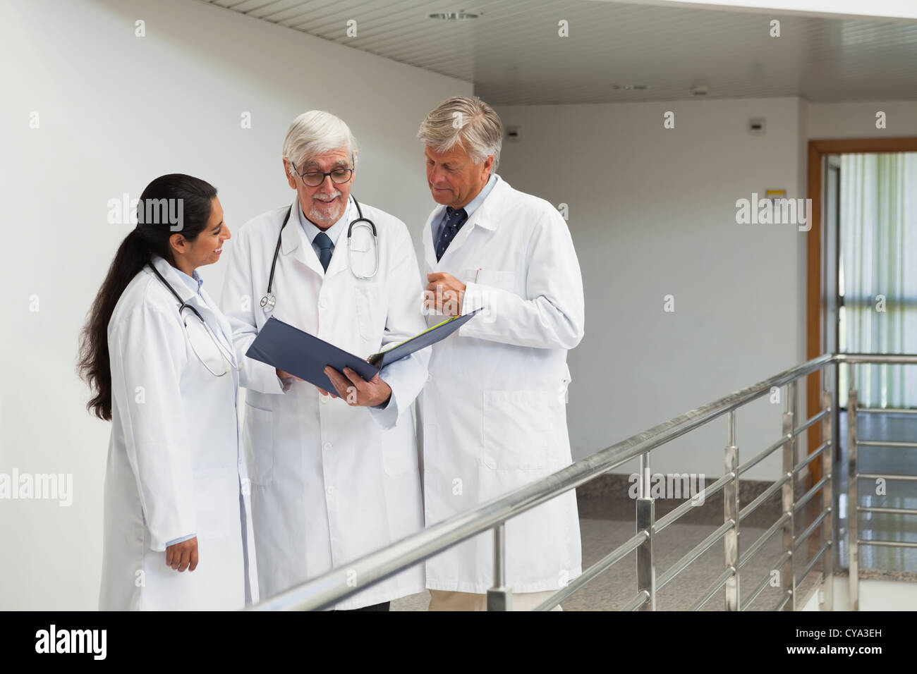 Three doctors talking Stock Photo - Alamy