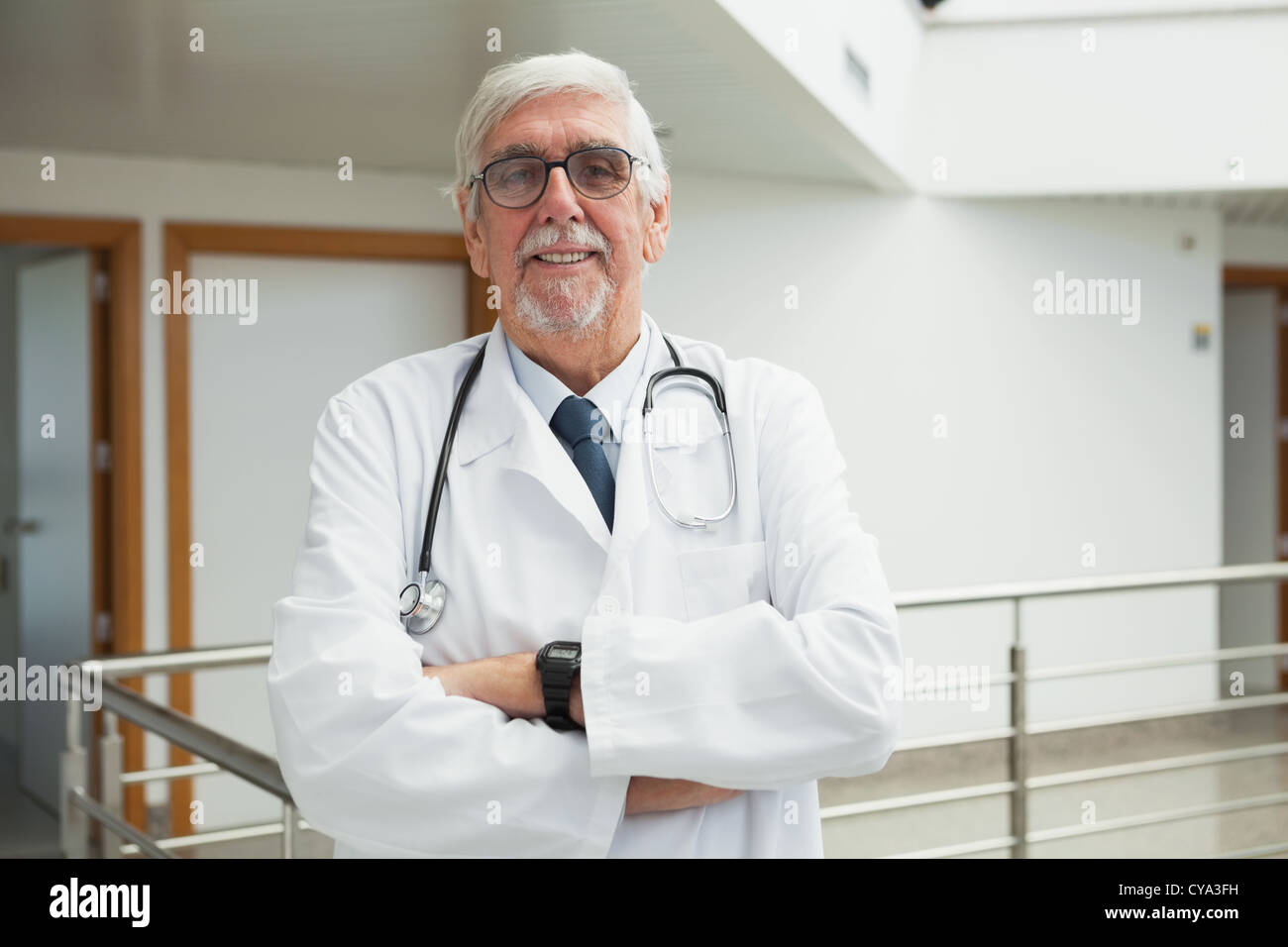 Doctor standing in the corridor smiling Stock Photo - Alamy