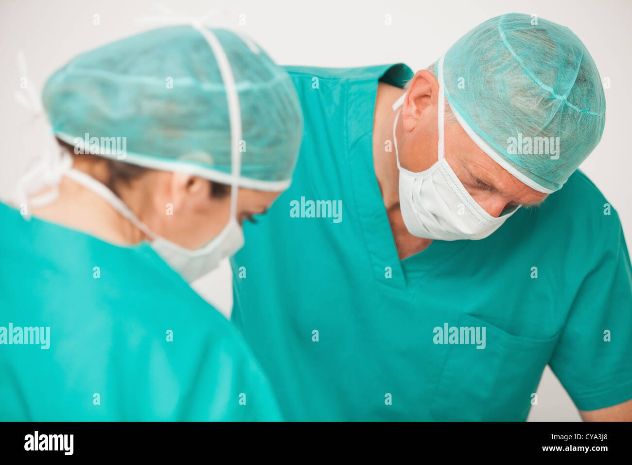 Two surgeons looking down on patient Stock Photo - Alamy