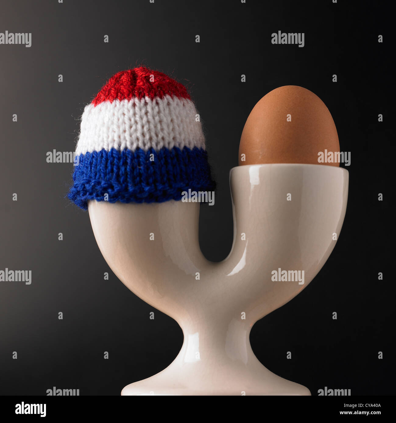 Two eggs in double eggcup one covered in woollen egg warmer Stock Photo ...