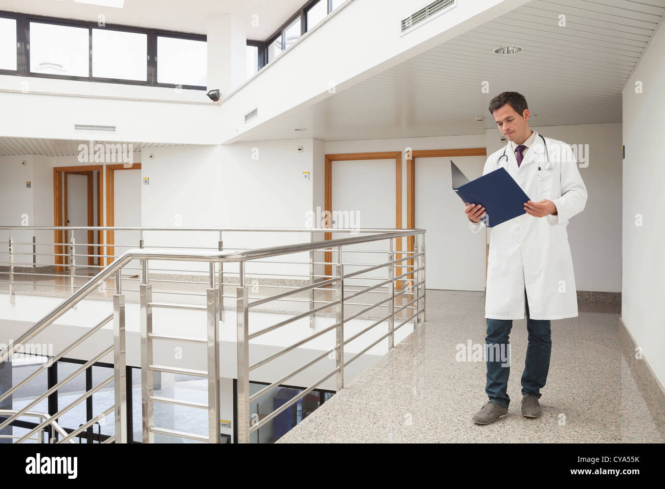 Doctor checking folder Stock Photo - Alamy