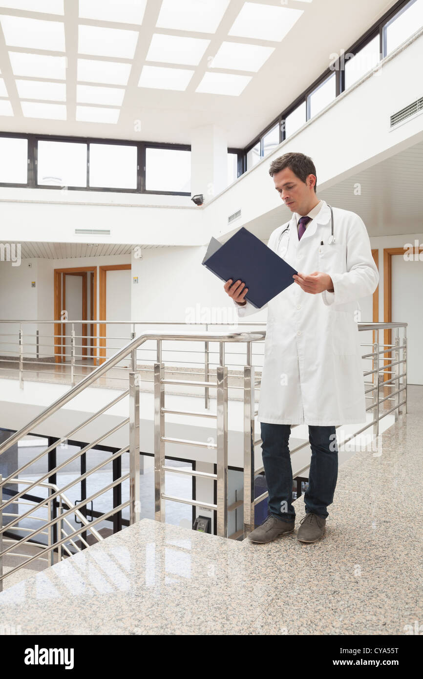 Doctor looking in his folder in hallway Stock Photo - Alamy