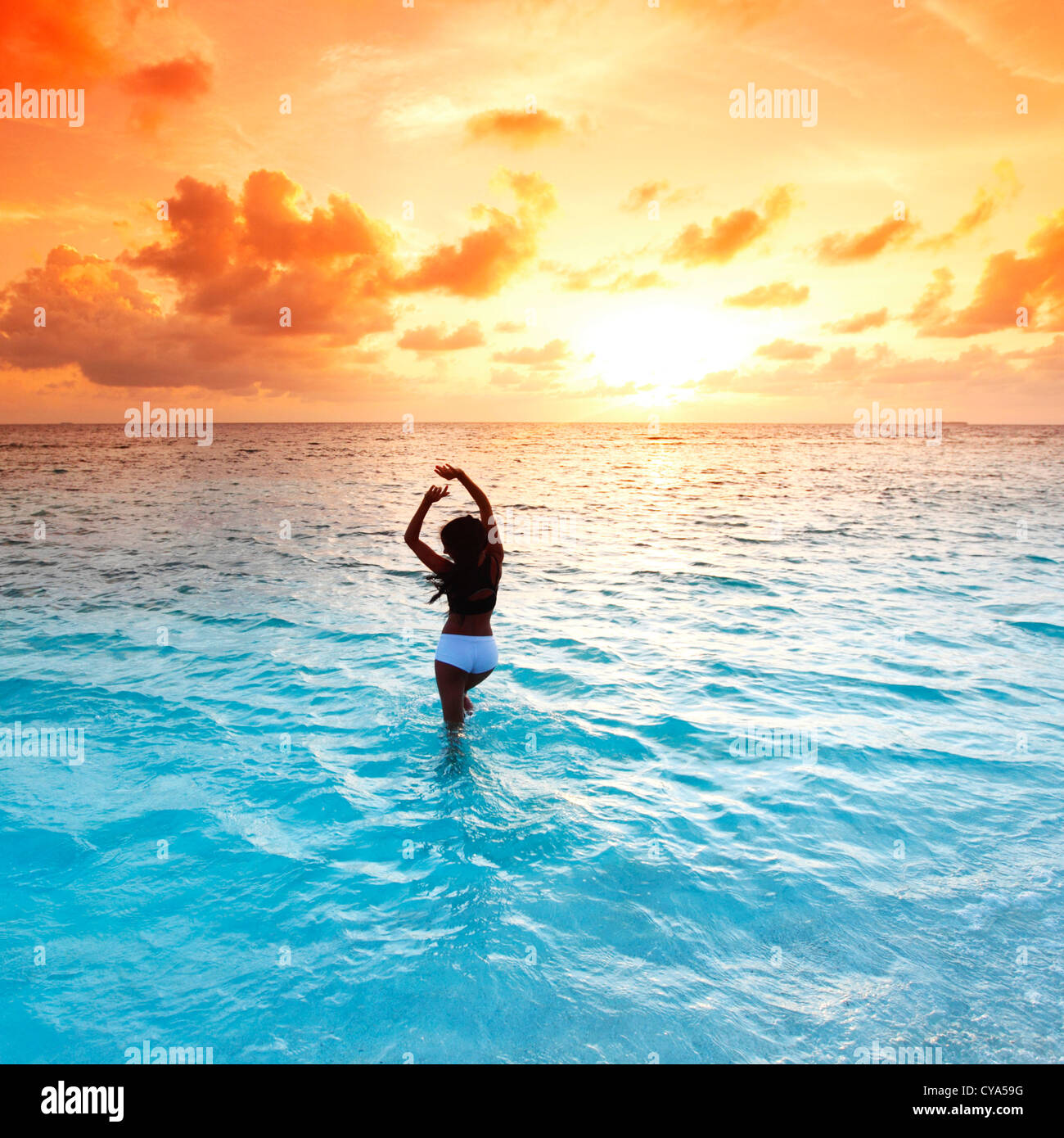 Young woman enjoy sunset in ocean water Stock Photo - Alamy