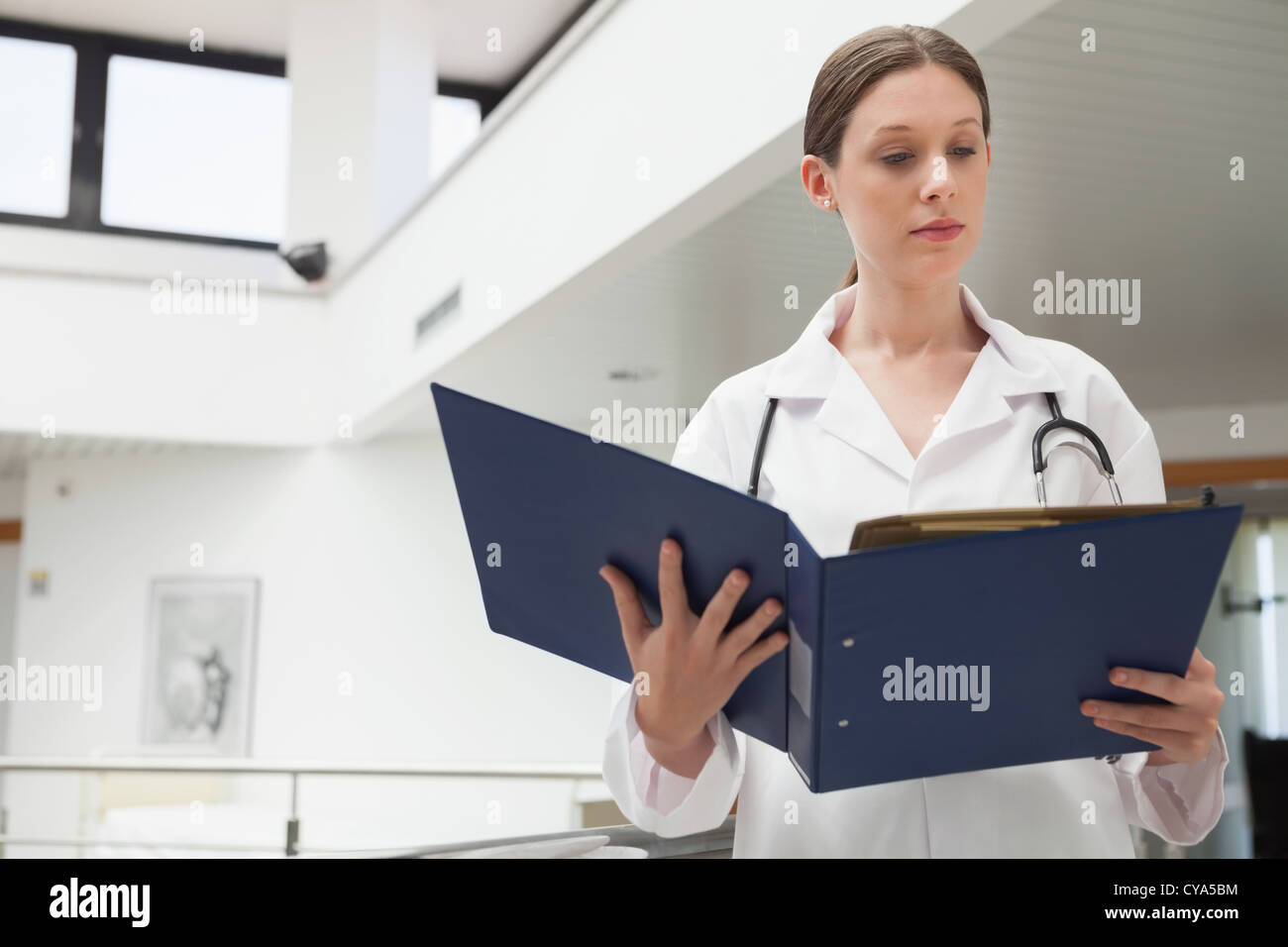 Female doctor reading folder Stock Photo - Alamy
