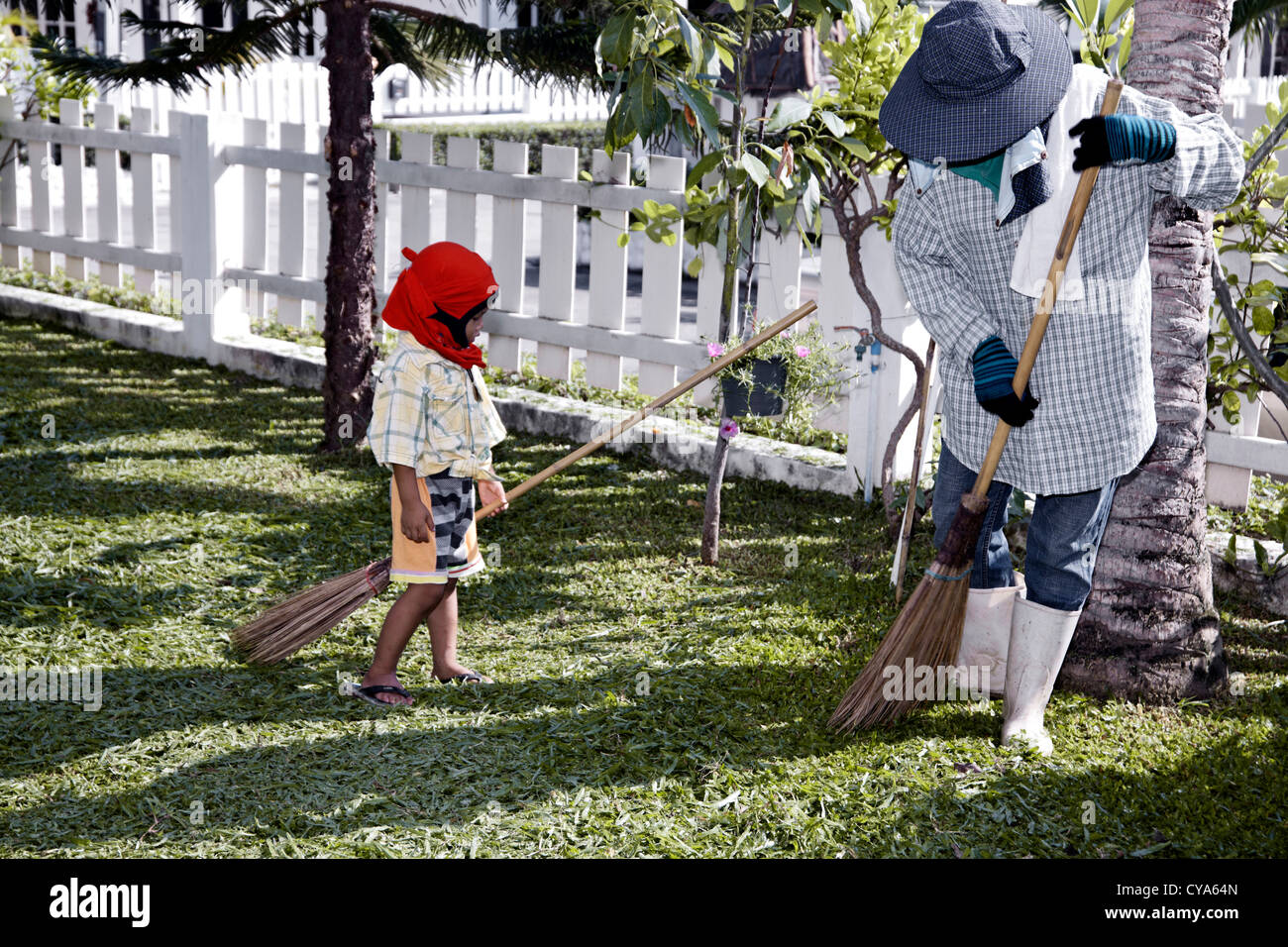 Child helping mother. 3 year old Thai child helping his mother with the ...