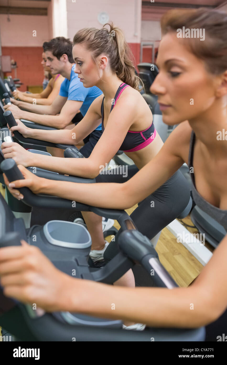 Four people on exercise bikes Stock Photo - Alamy