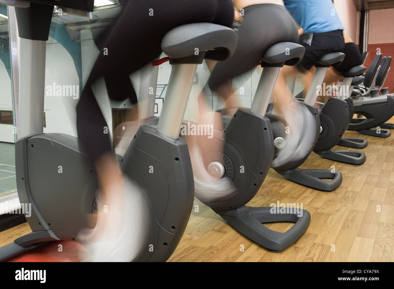 People riding on exercise bikes Stock Photo - Alamy