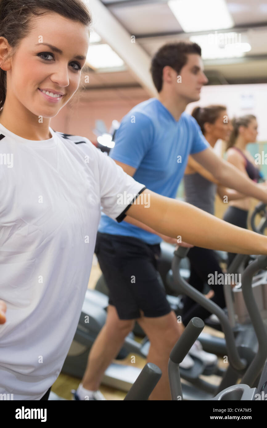 Smiling woman with other people stepping on step machines Stock Photo ...