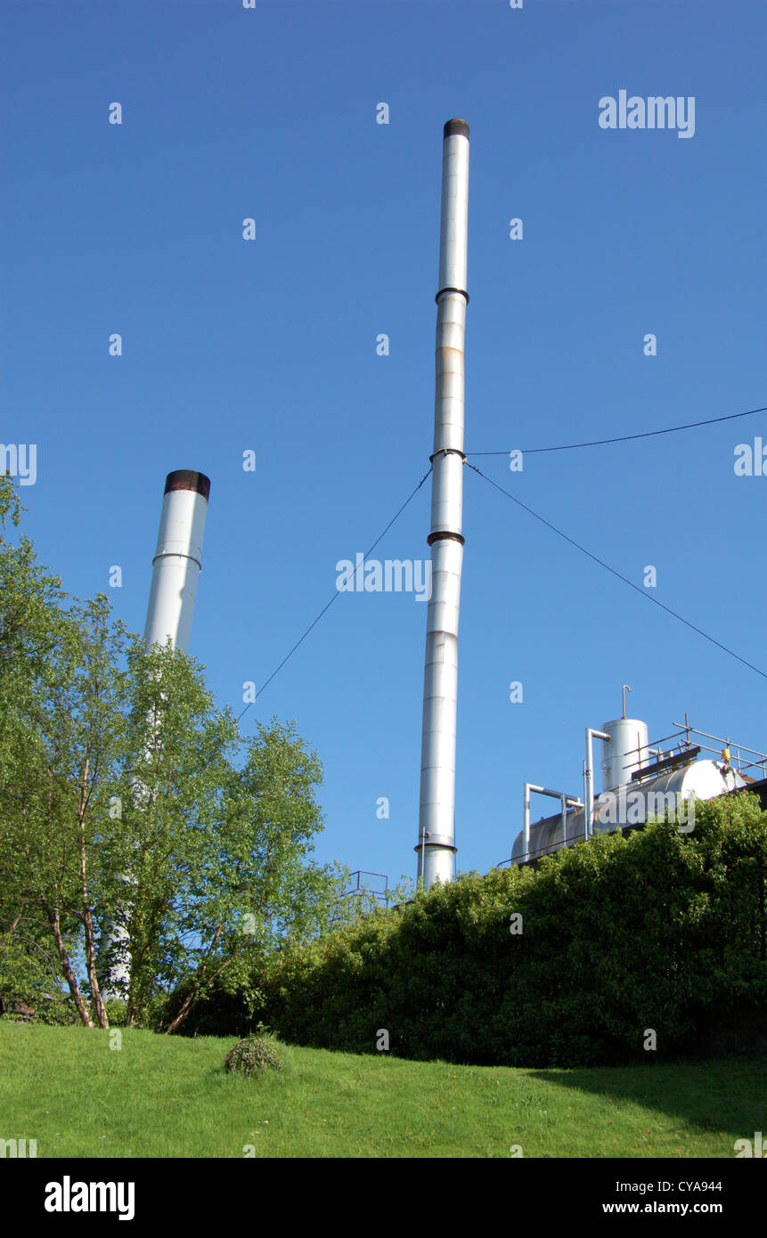 Open grass area with brewery chimneys in the background Stock Photo - Alamy