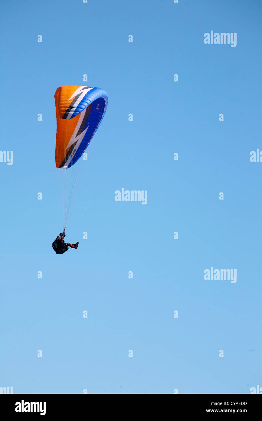 Man paragliding against a clear blue sky Stock Photo - Alamy