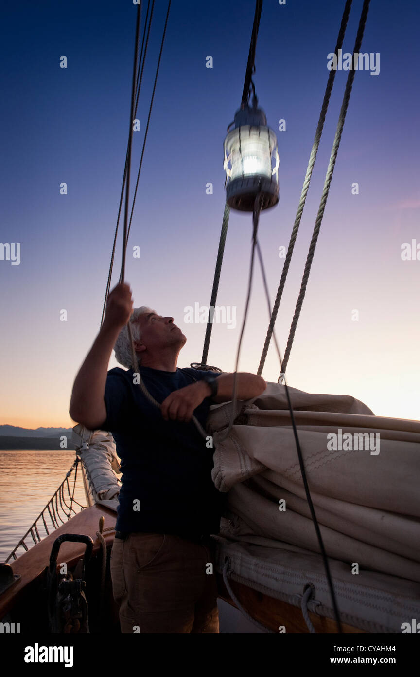A crew member aboard the historic tall ship "Zodiac" raises a night ...