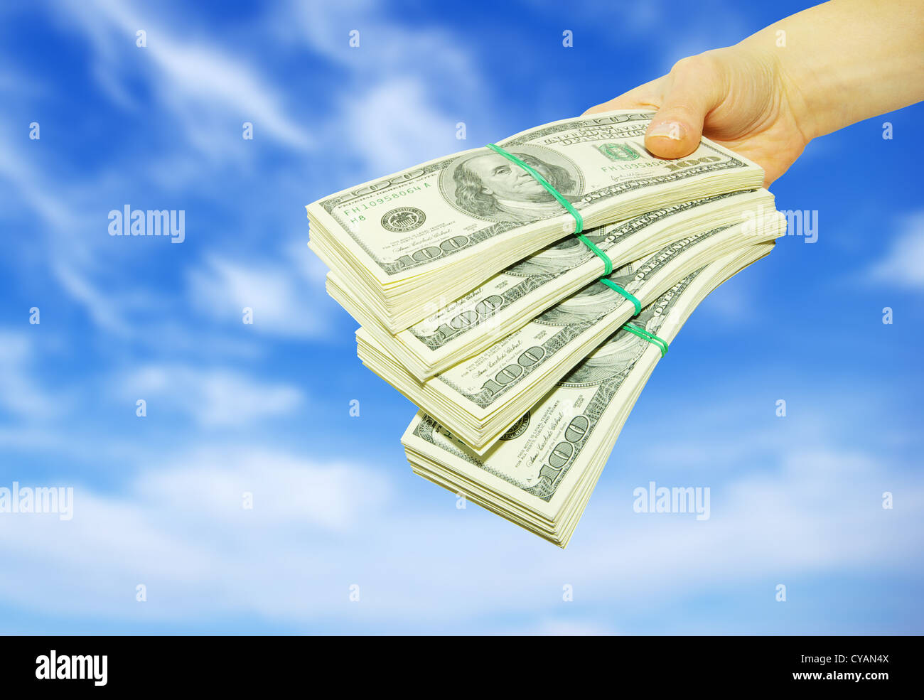 Hand with money isolated on sky background Stock Photo - Alamy