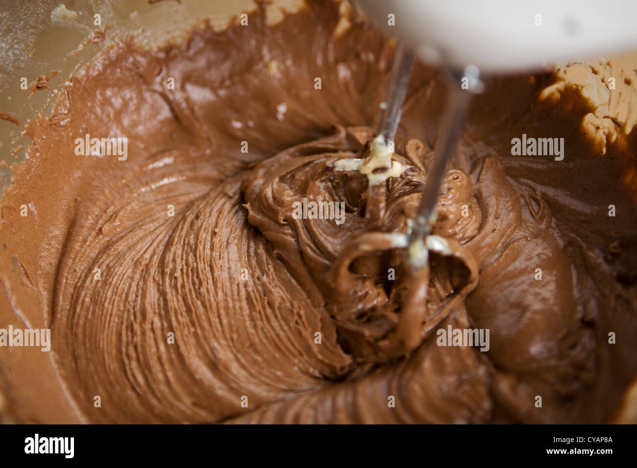 Homemade chocolate cake batter being mixed in a bowl using an electric ...