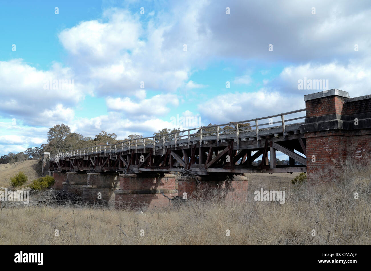 Old disused brick and timber railway bridge over dry river bed ...