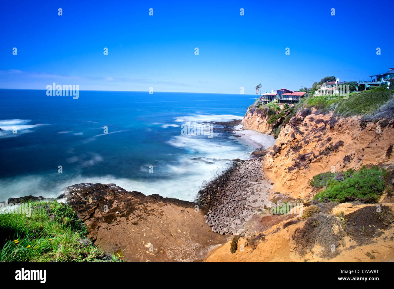 A scenic shot of a cliff side home that overlooks the rugged ocean ...