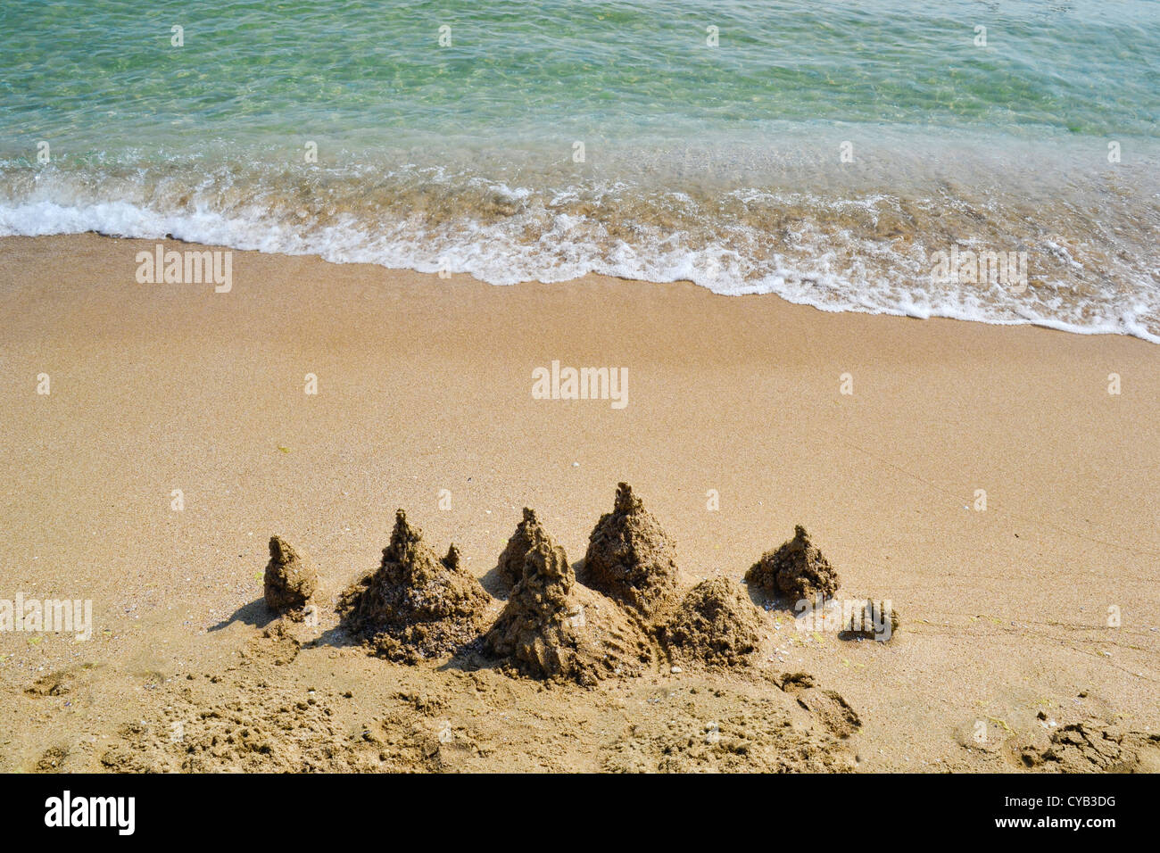 Sand castle on an empty beach with gentle ocean surf Stock Photo - Alamy