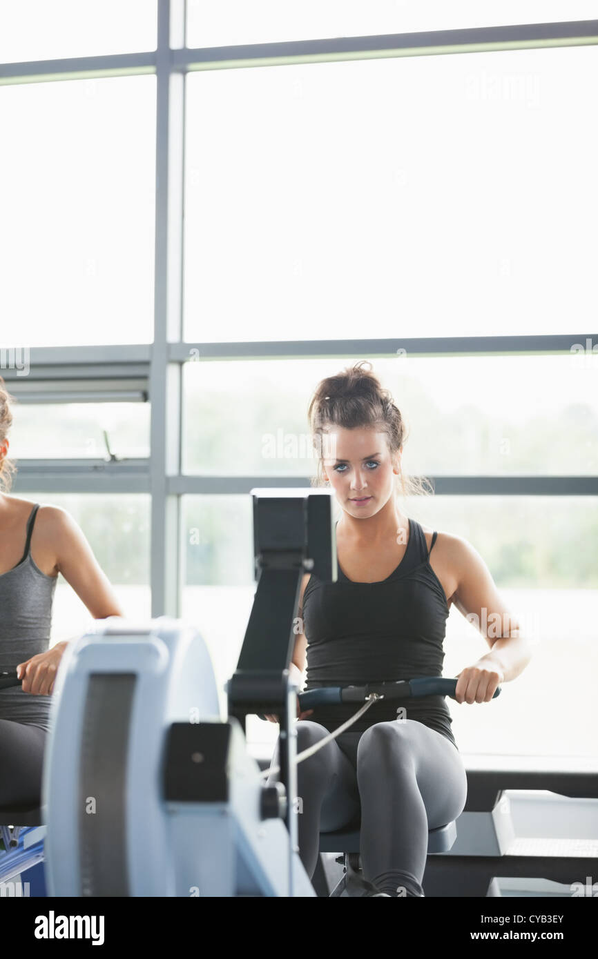 Two women training on row machines Stock Photo - Alamy