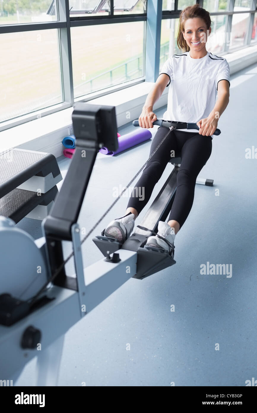 Smiling woman training on row machine Stock Photo - Alamy