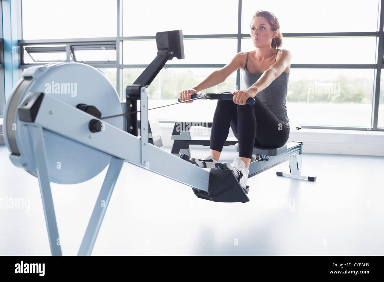 Woman training on row machine Stock Photo - Alamy