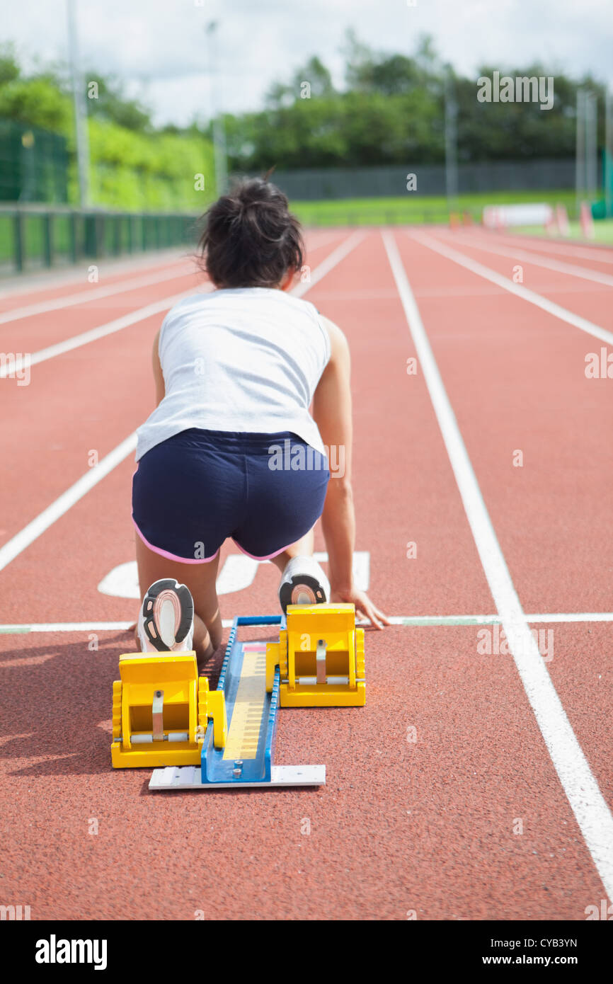 Woman at starting blocks on track Stock Photo - Alamy