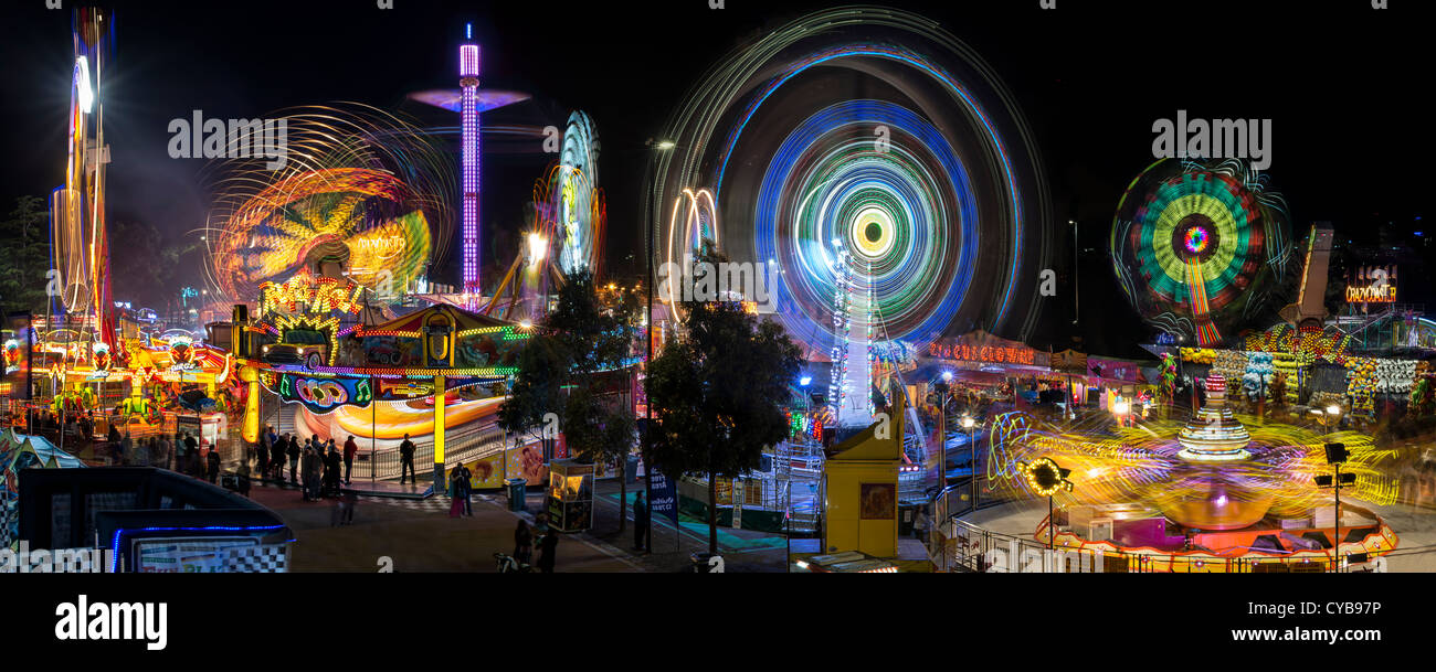 A night time panorama of the colorful light trails of the rides at the ...