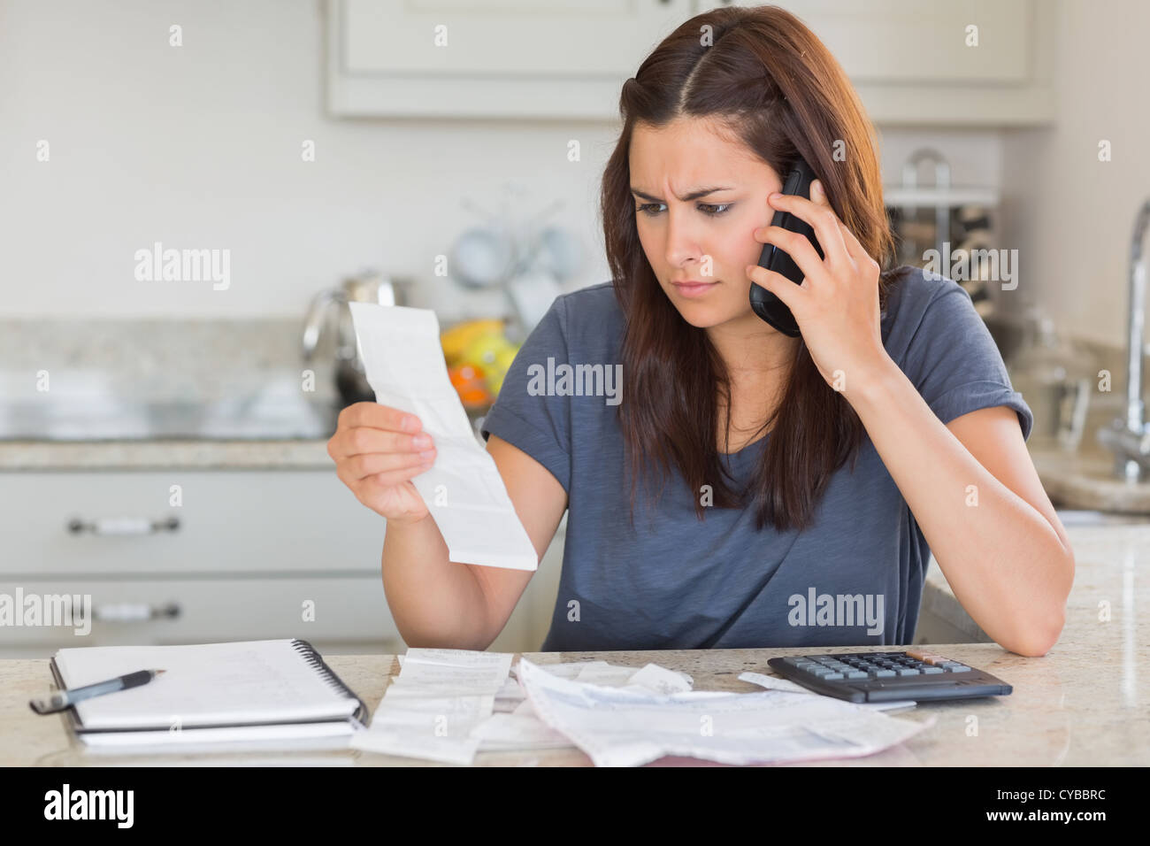 Woman calling while calculating Stock Photo - Alamy