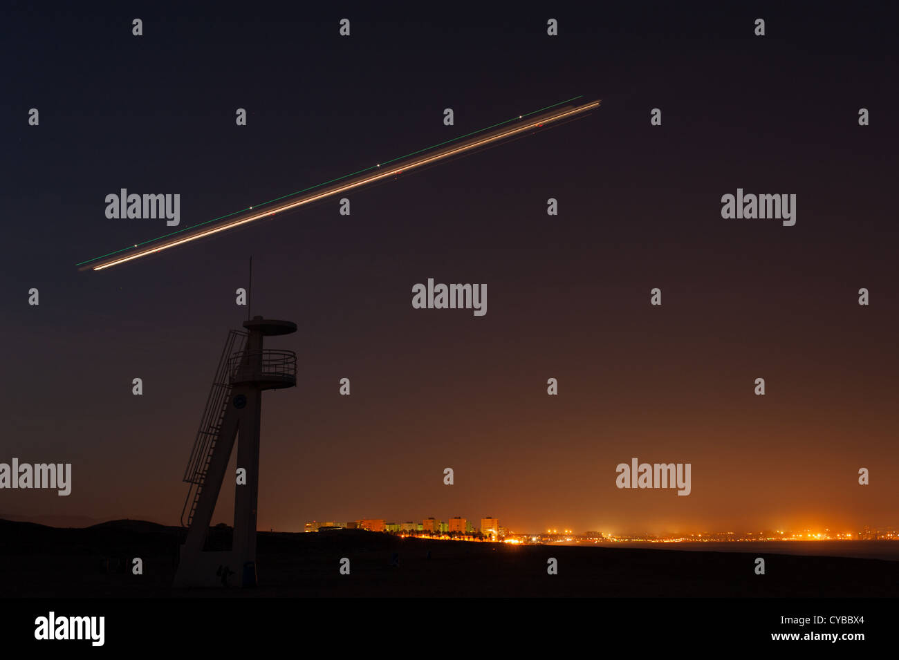 Jetliner taking off at night over a Mediterranean resort Stock Photo ...