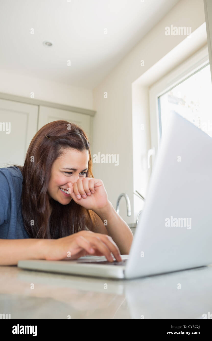 Woman typing on laptop while laughing Stock Photo - Alamy