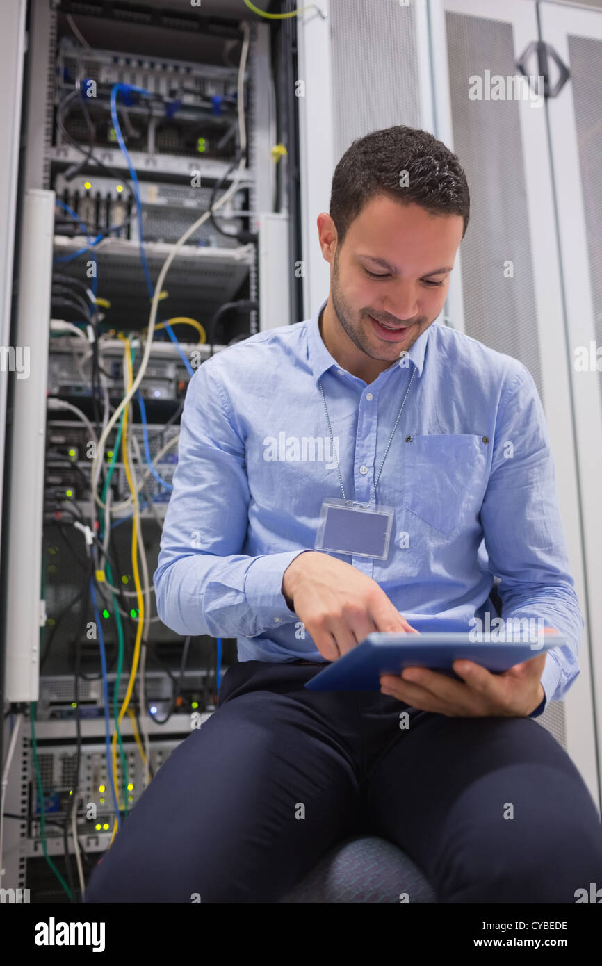 Technician using tablet pc to work on servers Stock Photo - Alamy