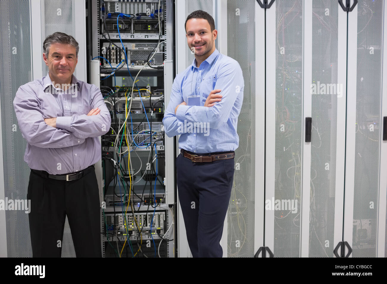 Two smiling men standing in front of servers Stock Photo - Alamy