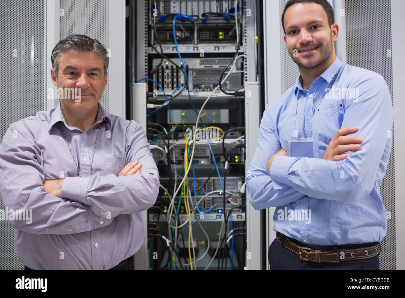 Technicians smiling while standing in front of servers Stock Photo - Alamy