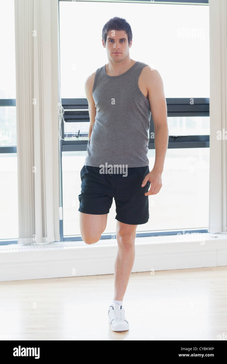 Man standing stretching his leg Stock Photo - Alamy