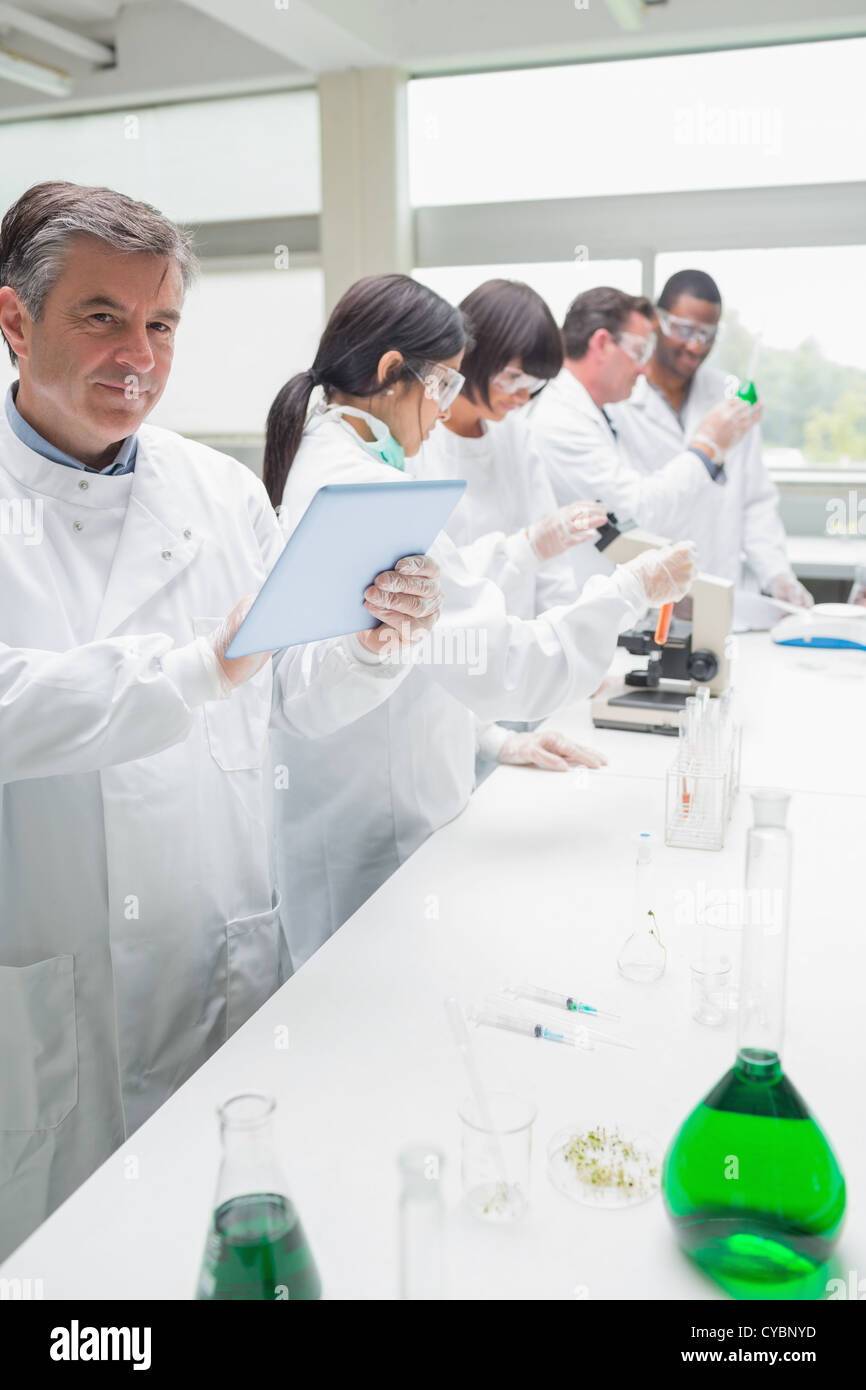Happy chemist using tablet pc Stock Photo - Alamy