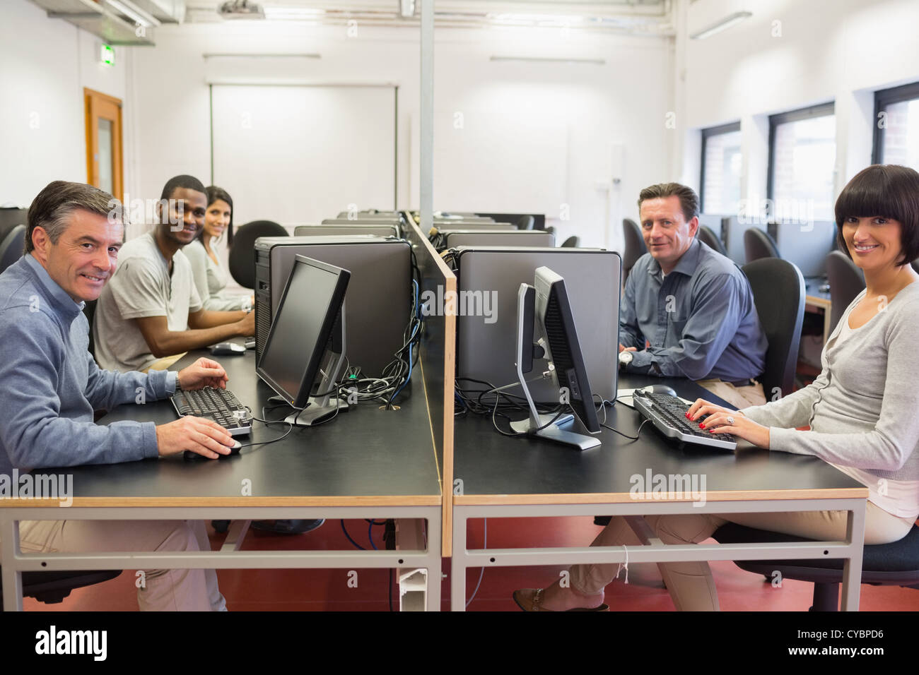 Happy group in a computer room Stock Photo - Alamy