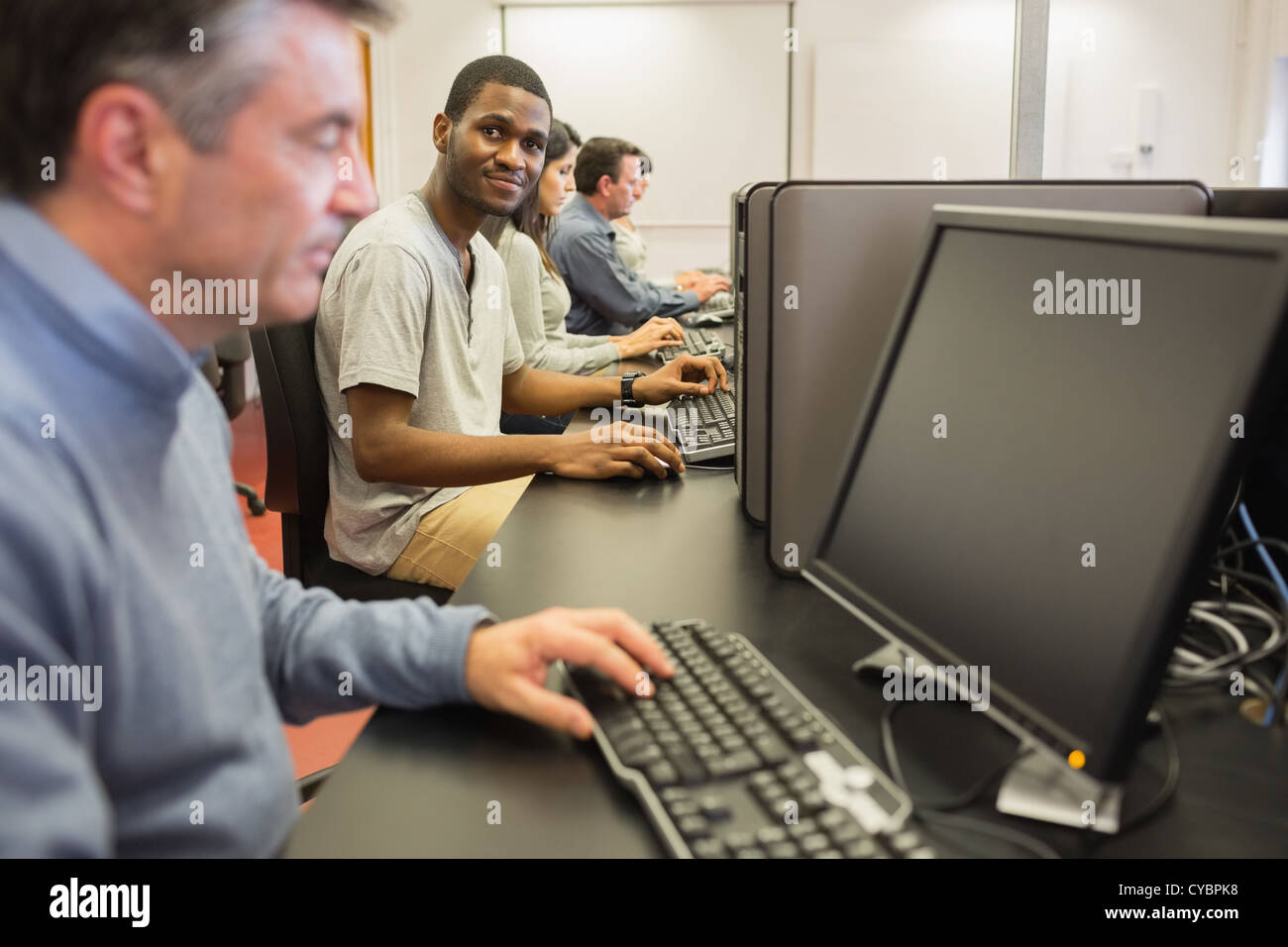 Man looking up from computer class Stock Photo - Alamy
