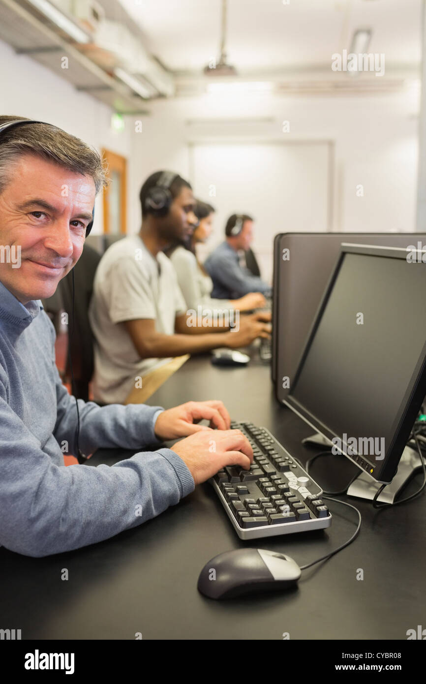 Smiling man in computer class Stock Photo - Alamy