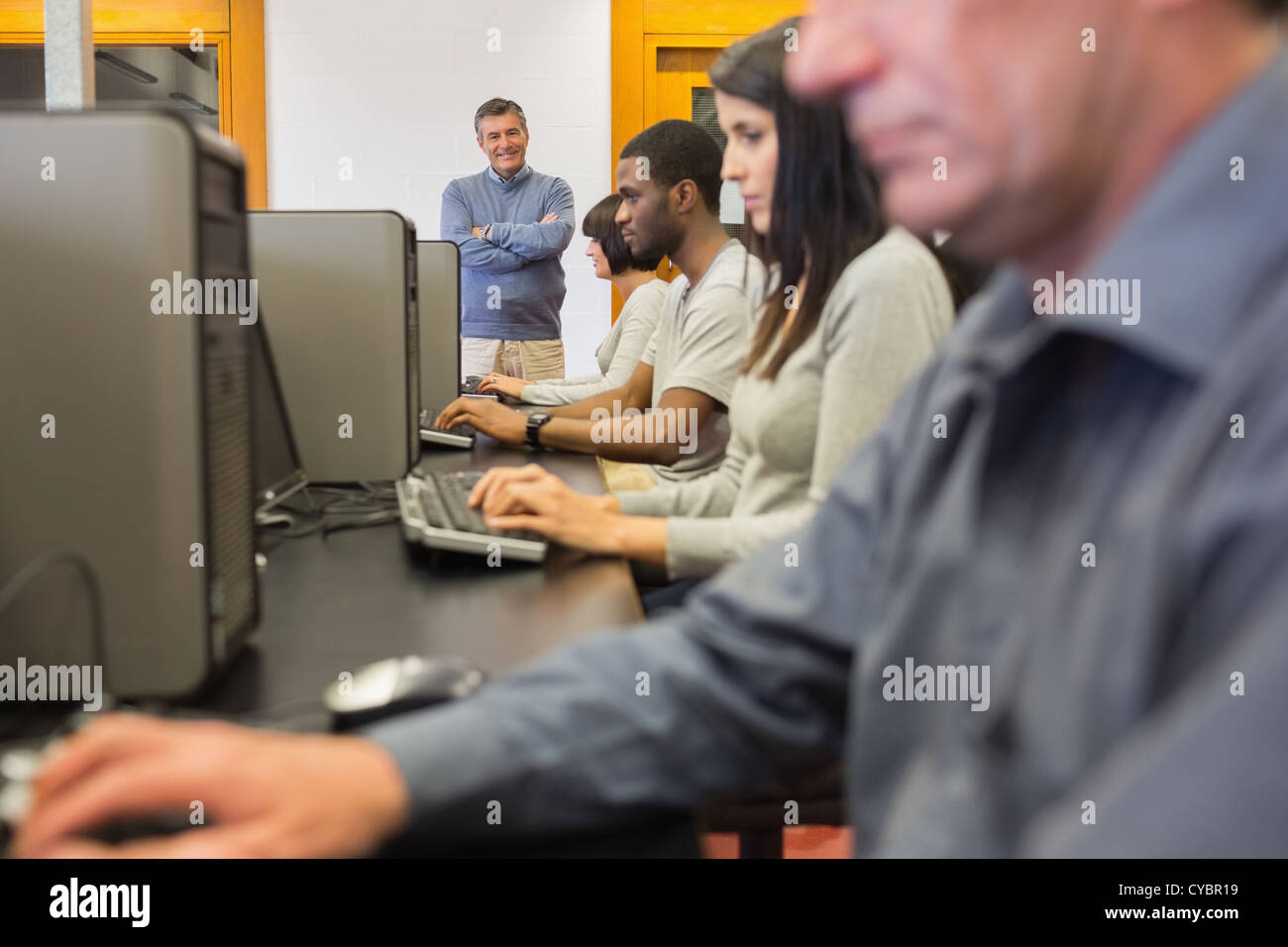 Teacher standing at front of computer class Stock Photo - Alamy