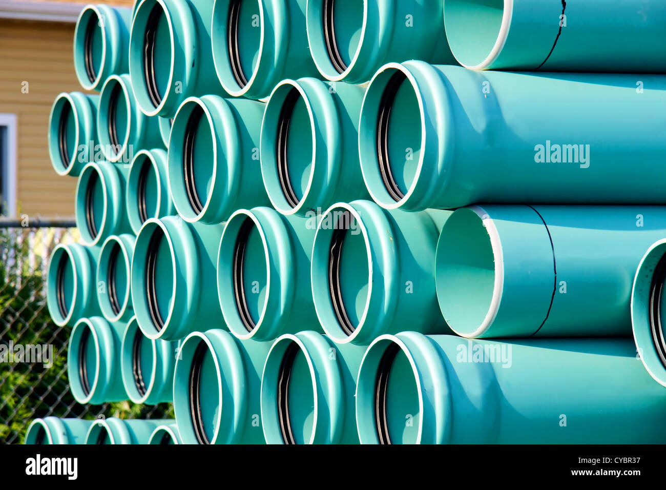 Stack of blue plastic PVC water pipe to be used in a new development of ...