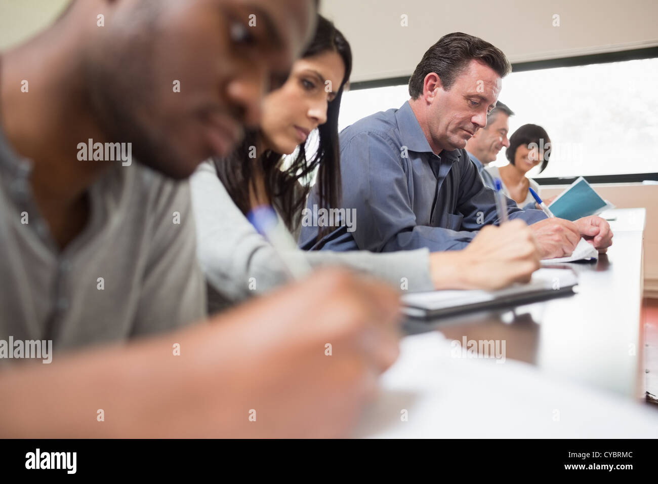 Students in a lecture with one woman looking up Stock Photo - Alamy