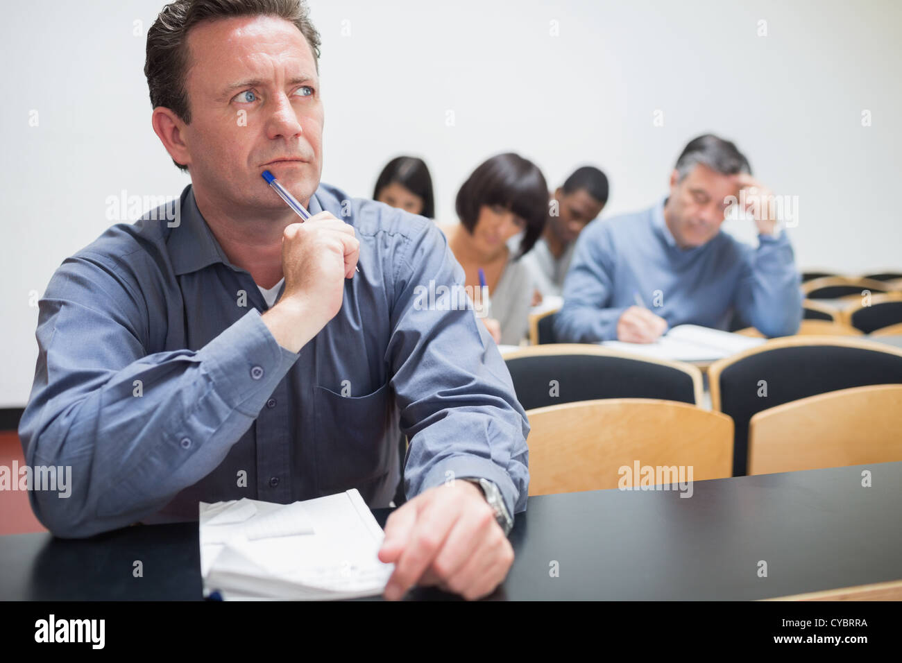 Man thinking while writing Stock Photo - Alamy