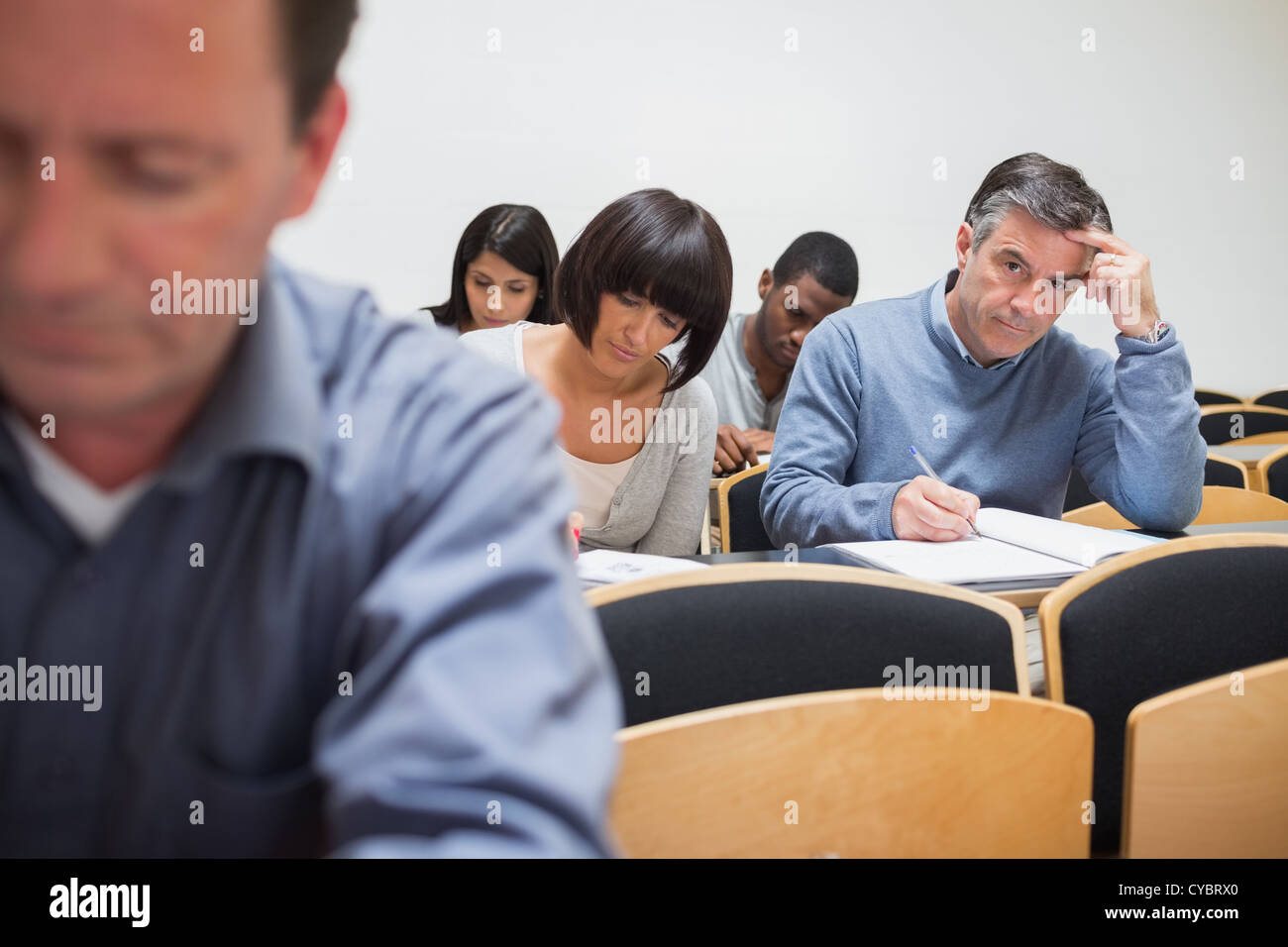Man looking up from taking notes Stock Photo - Alamy