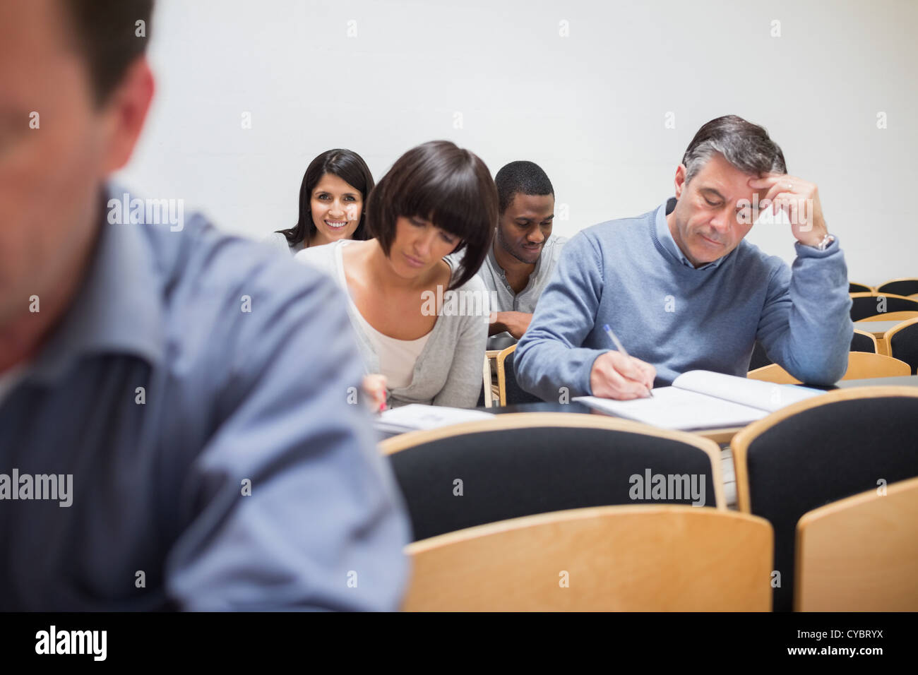Adult class taking notes Stock Photo - Alamy