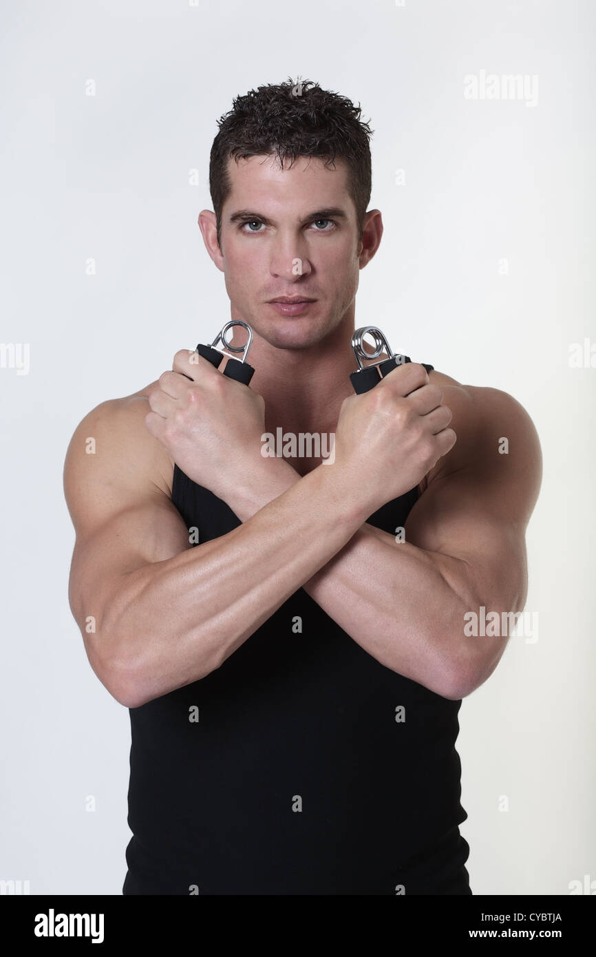 good looking male bodybuilder using hand gripper Stock Photo - Alamy