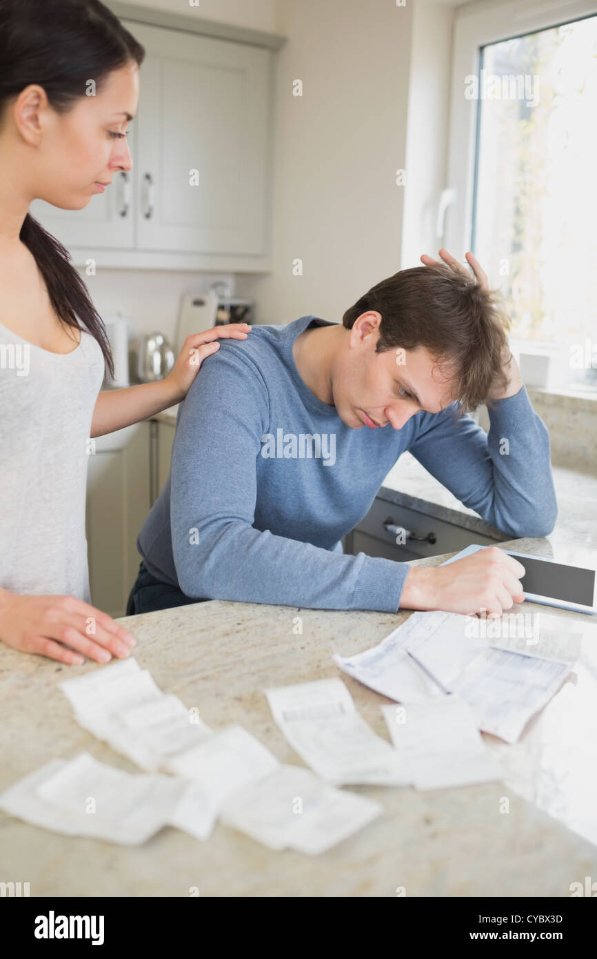 Wife comforting stressed husband over bills Stock Photo - Alamy