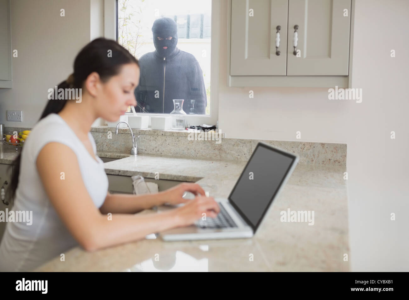 Burglar observing woman in the kitchen Stock Photo - Alamy