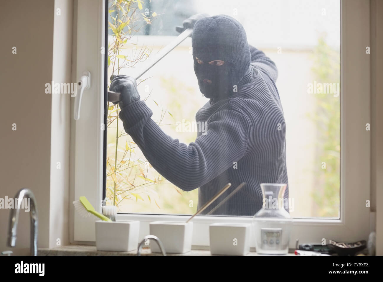 Burglar breaking a kitchen window Stock Photo - Alamy