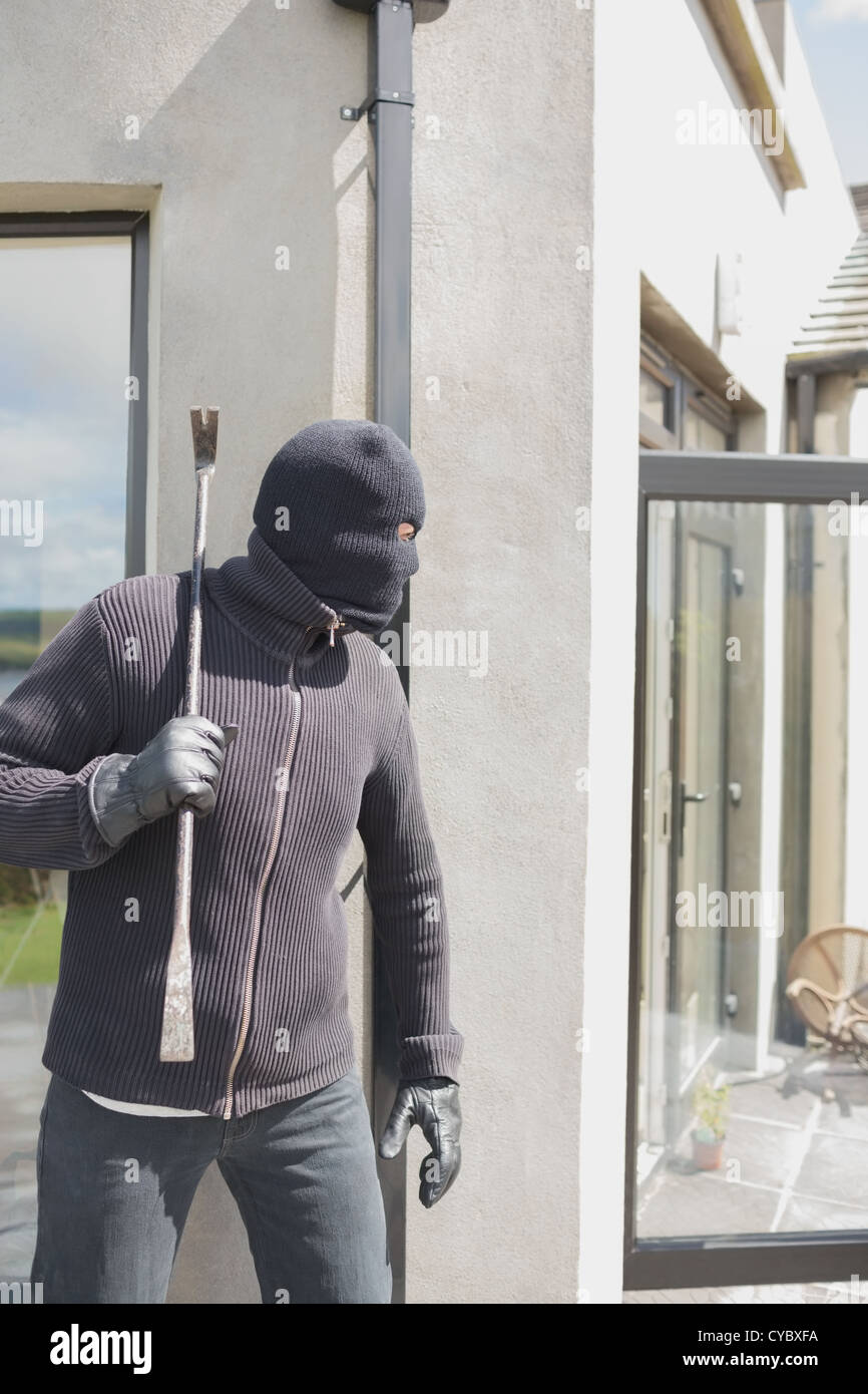 Robber hiding behind a wall Stock Photo - Alamy