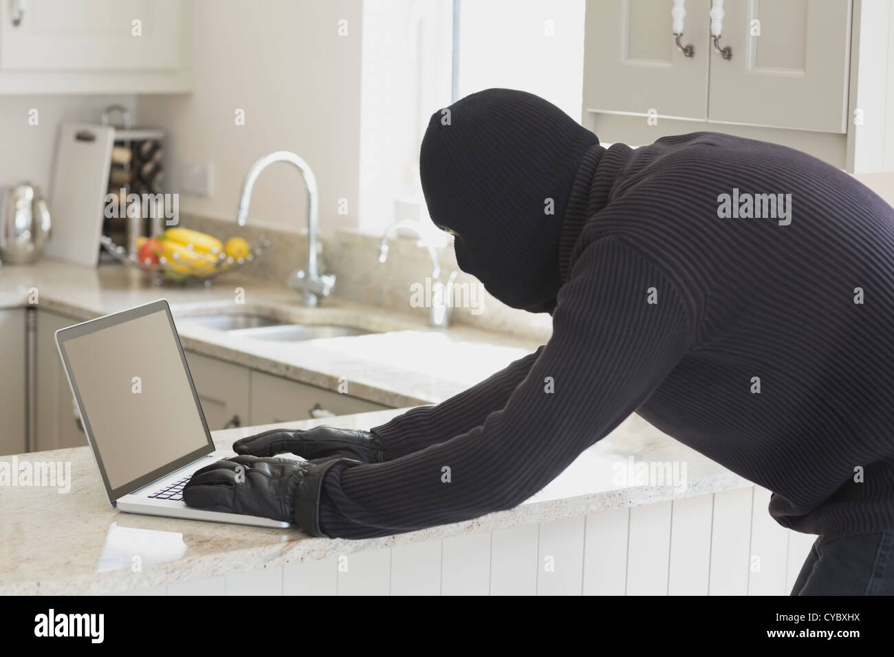 Robber using laptop Stock Photo - Alamy